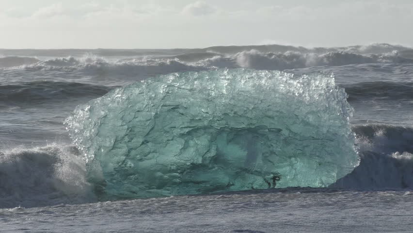 Iceberg On The Beach And Sea Surf In The Background Filmati e video d ...
