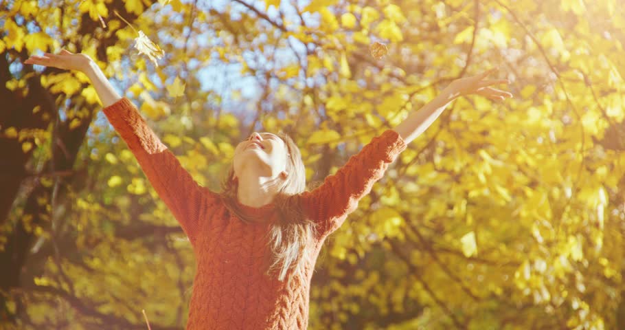 Stock Video Clip of Happy woman throwing leaves in Autumn in | Shutterstock