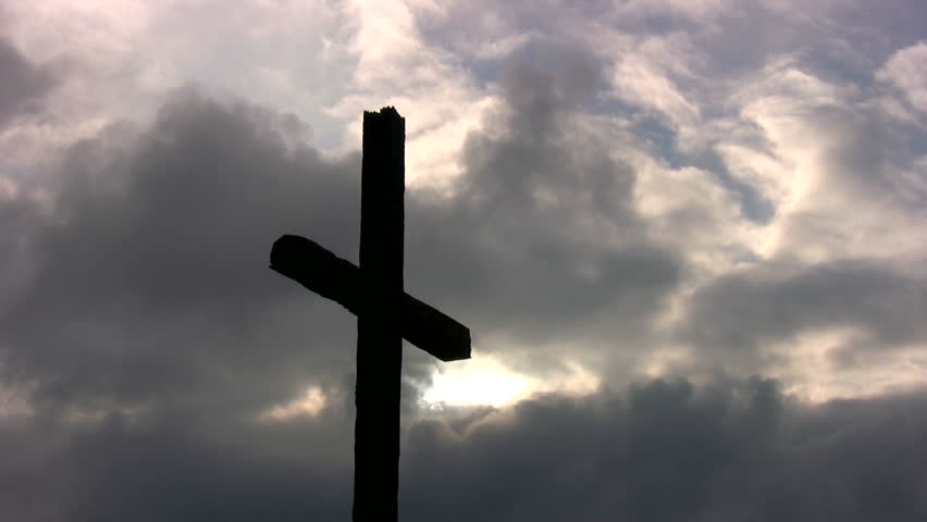 Stock Video Clip of A large cross silhouetted against storm clouds ...