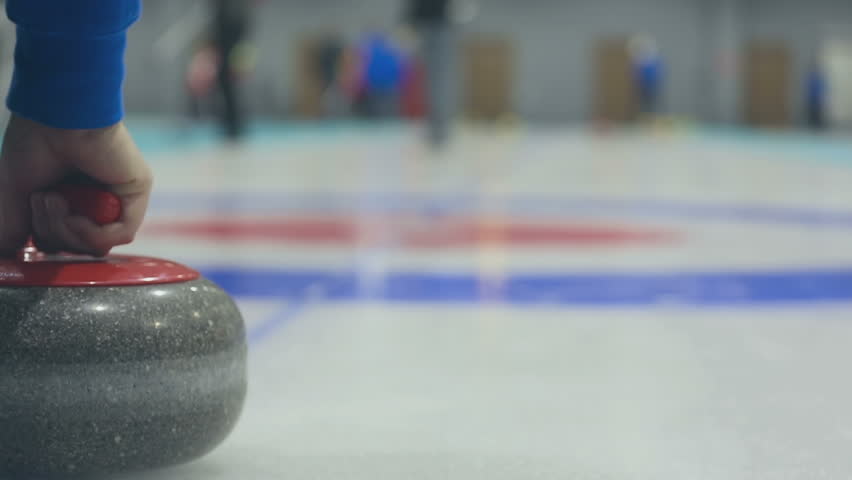 Curling Player Delivering A Stone On A Curling Rink, Sliding Over The ...