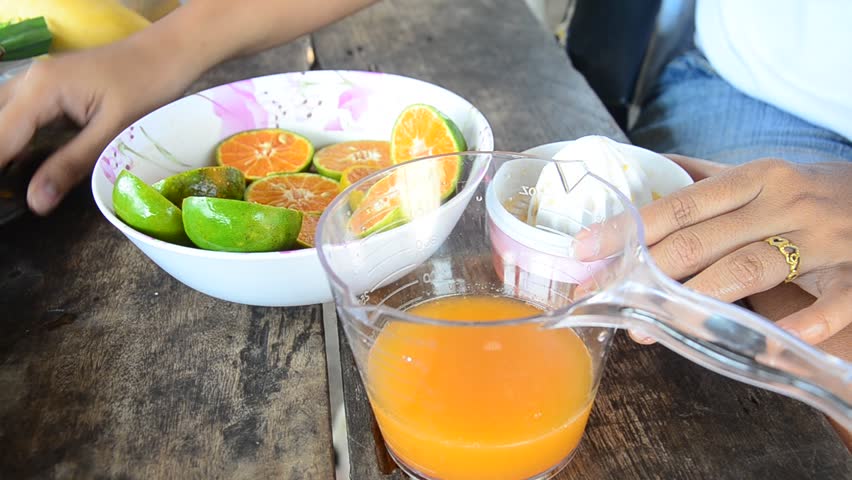 Stock Video Clip of Made orange juice by fruit crush hand | Shutterstock