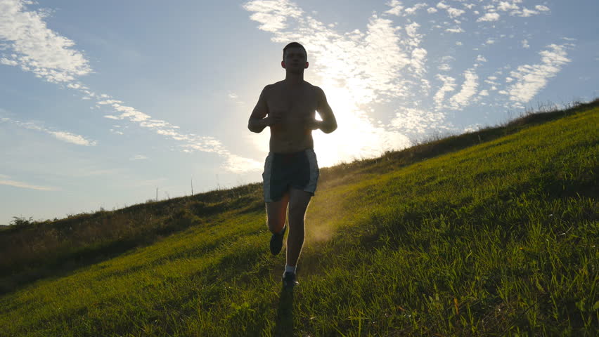 Young Men Running Over Green Hill Over Blue Sky Background. Male ...