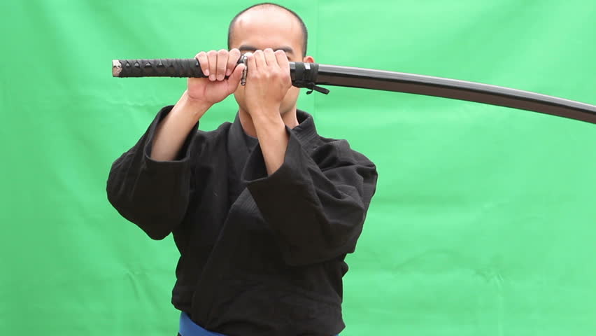 An Asian Man In A Japanese Gi Draws A Samurai Sword (Katana), And ...