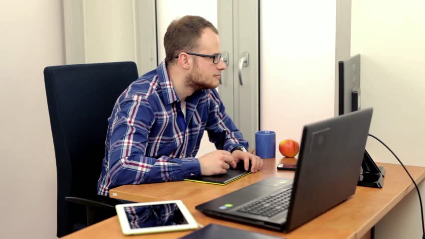 Handsome Men Sitting Behind The Desk And Using Computer, He Is Focused ...