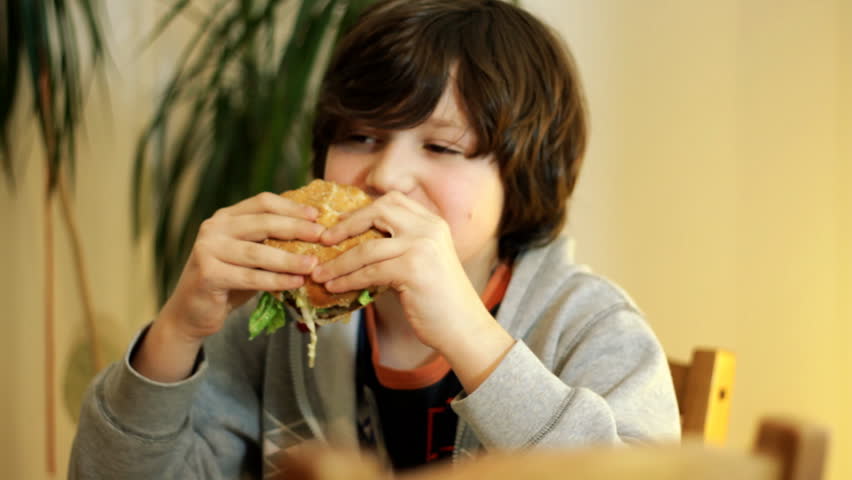 Girl Sitting At Table Eating Large Messy Slice Of Chocolate Cake. Shot ...